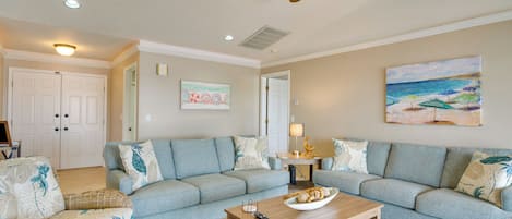 Sala de estar com sofá, mesa de centro e ventilador de teto.