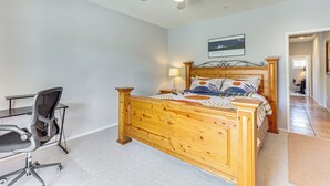 Quarto com cama de madeira, escrivaninha e cadeira.