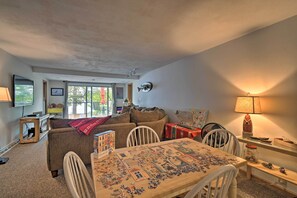 Uma sala de estar aconchegante com uma grande mesa para jogos de quebra-cabeça, assentos confortáveis e uma televisão.