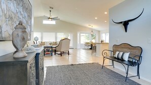 Uma sala de estar ampla com uma mesa de jantar, um banco e uma decoração de cabeça de touro fixada na parede.
