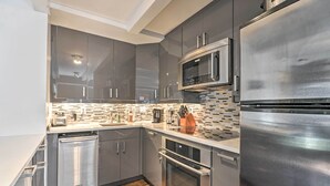 Uma cozinha moderna com eletrodomésticos de aço inoxidável, micro-ondas e máquina de lavar louça.