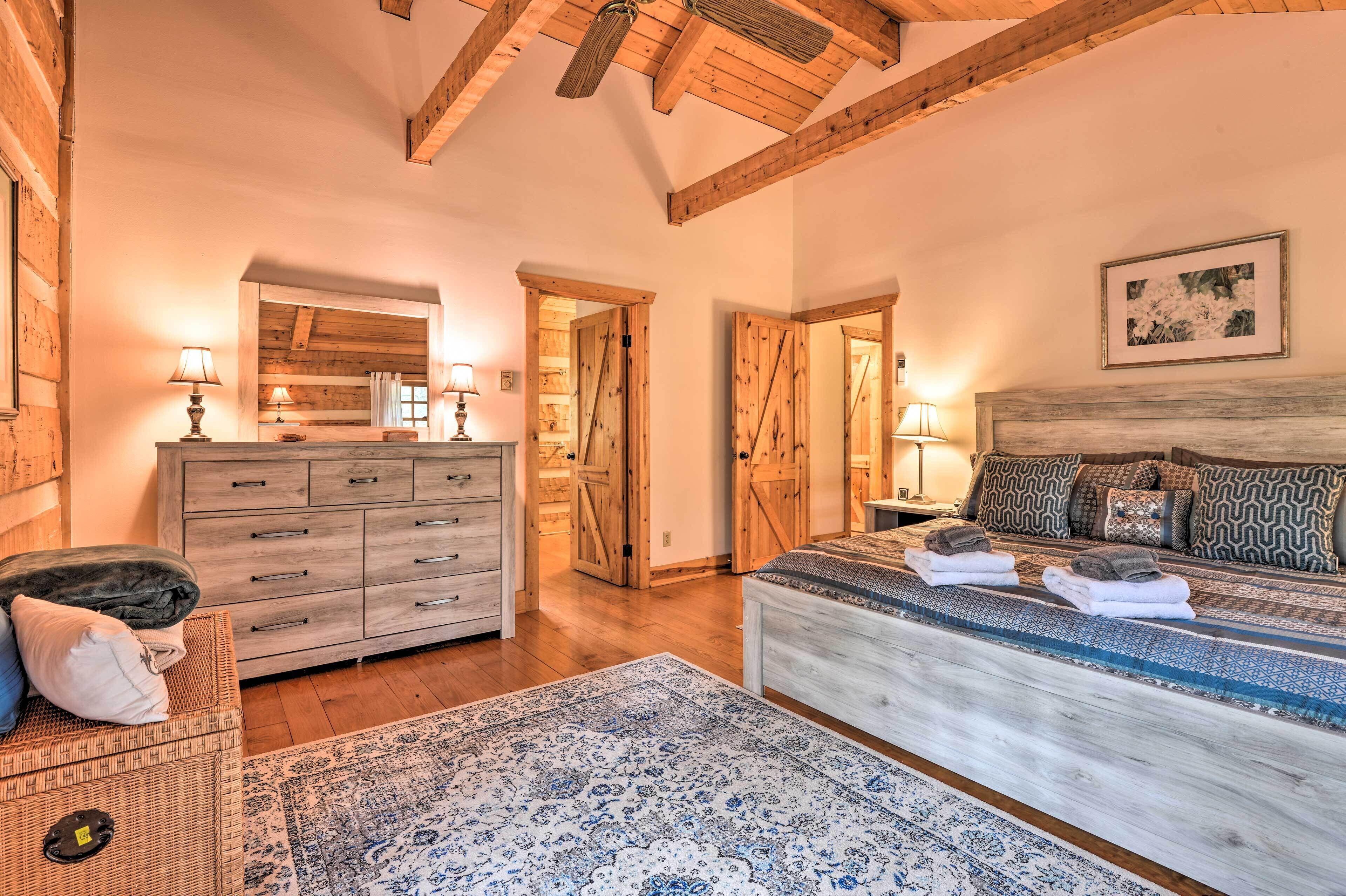 Quarto com uma cama grande, guarda-roupa de madeira e espelho.
