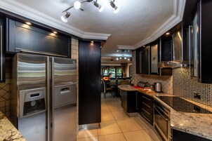 Uma cozinha moderna com eletrodomésticos de aço inoxidável, um bebedouro e uma área de refeições com vista.