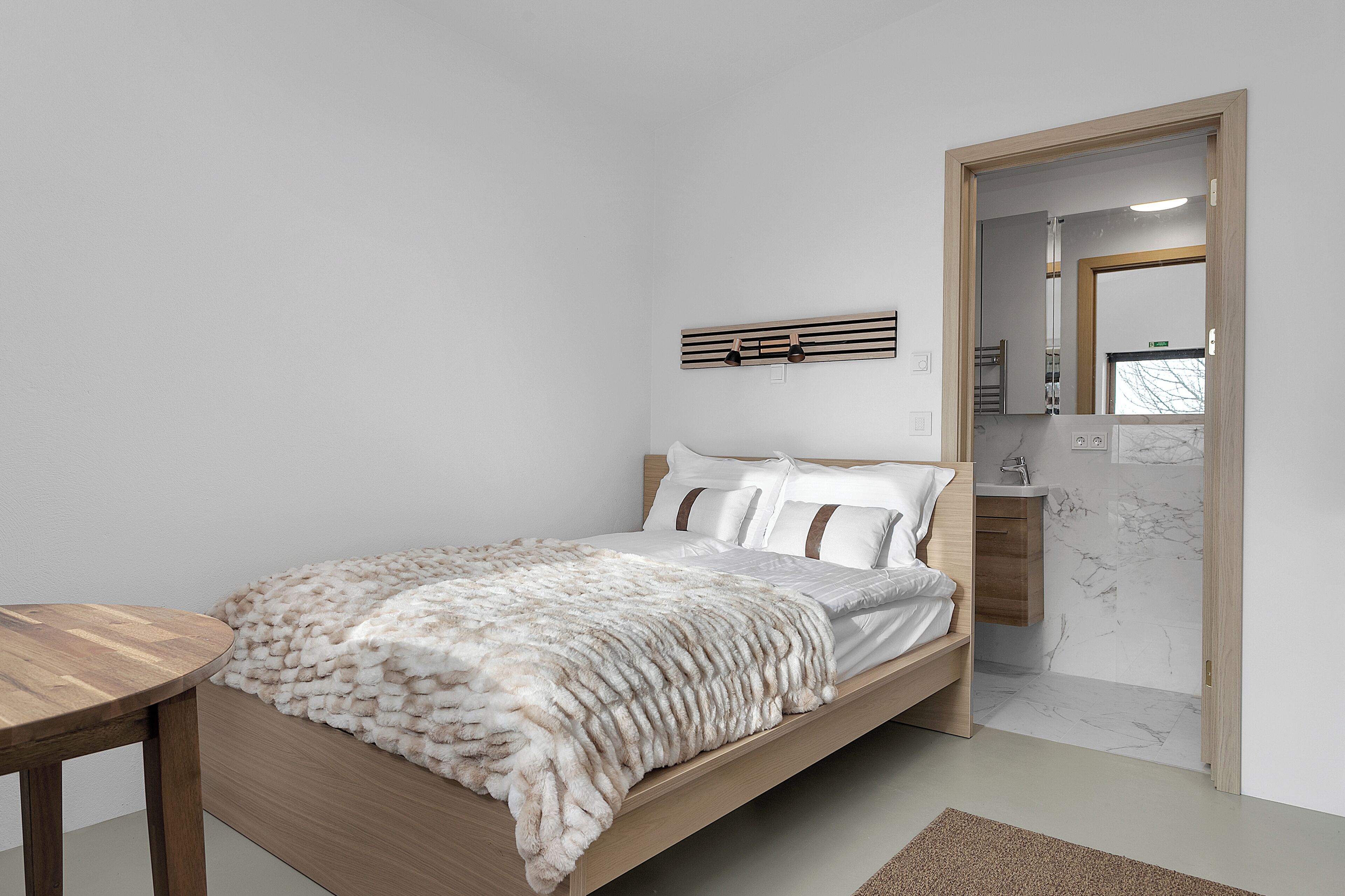 Quarto moderno com cama de madeira, mesa de cabeceira e guarda-roupa embutido.