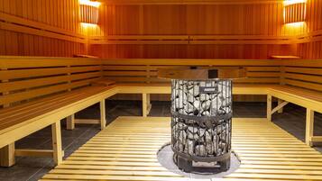 Uma sauna com bancos de madeira e aquecedor central de pedra.