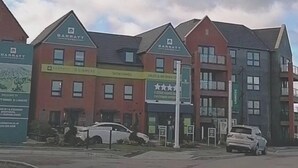 Uma fileira de edifícios altos com a sinalização 'BARRATT', indicando um hotel ou acomodação similar.