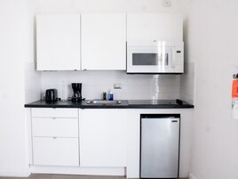 Um frigorífico, um micro-ondas, uma cafeteira/bule 