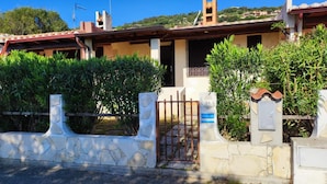 Um edifício residencial com entrada em parede de pedra, portão de metal e caixa de correio.