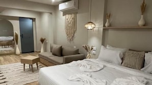 Quarto moderno com uma cama grande, um sofá, uma mesinha e um enfeite de parede.