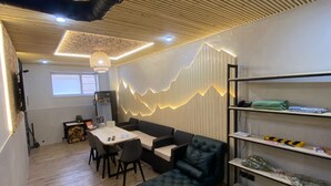 Um interior moderno com área de refeições, um sofá e uma estante na parede.