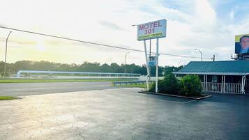 Um motel chamado 'Motel 301' com uma placa indicando 'quartos econômicos - tarifas baixas'.