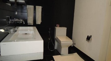 Casa de banho com lavatório branco, sanita e chuveiro.