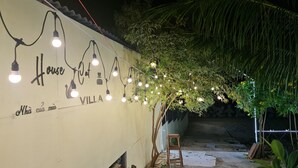 A wall with the text "House at Villa" and decorative lights.