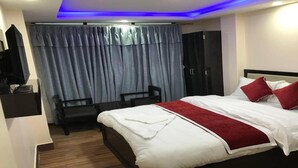 Quarto de hotel com uma cama, uma escrivaninha e uma cadeira.