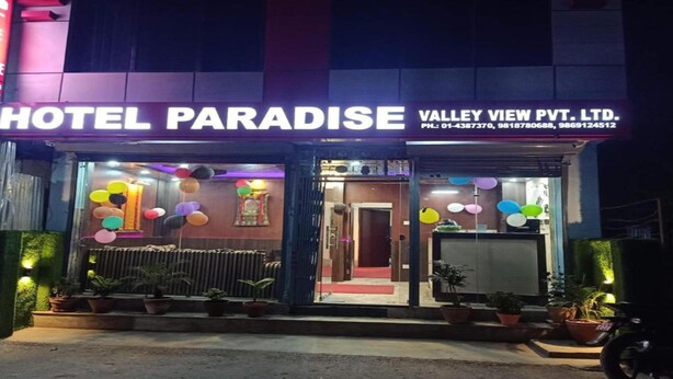 Um hotel chamado HOTEL PARADISE com uma placa indicando que é propriedade da VALLEY VIEW PVT. LTD.