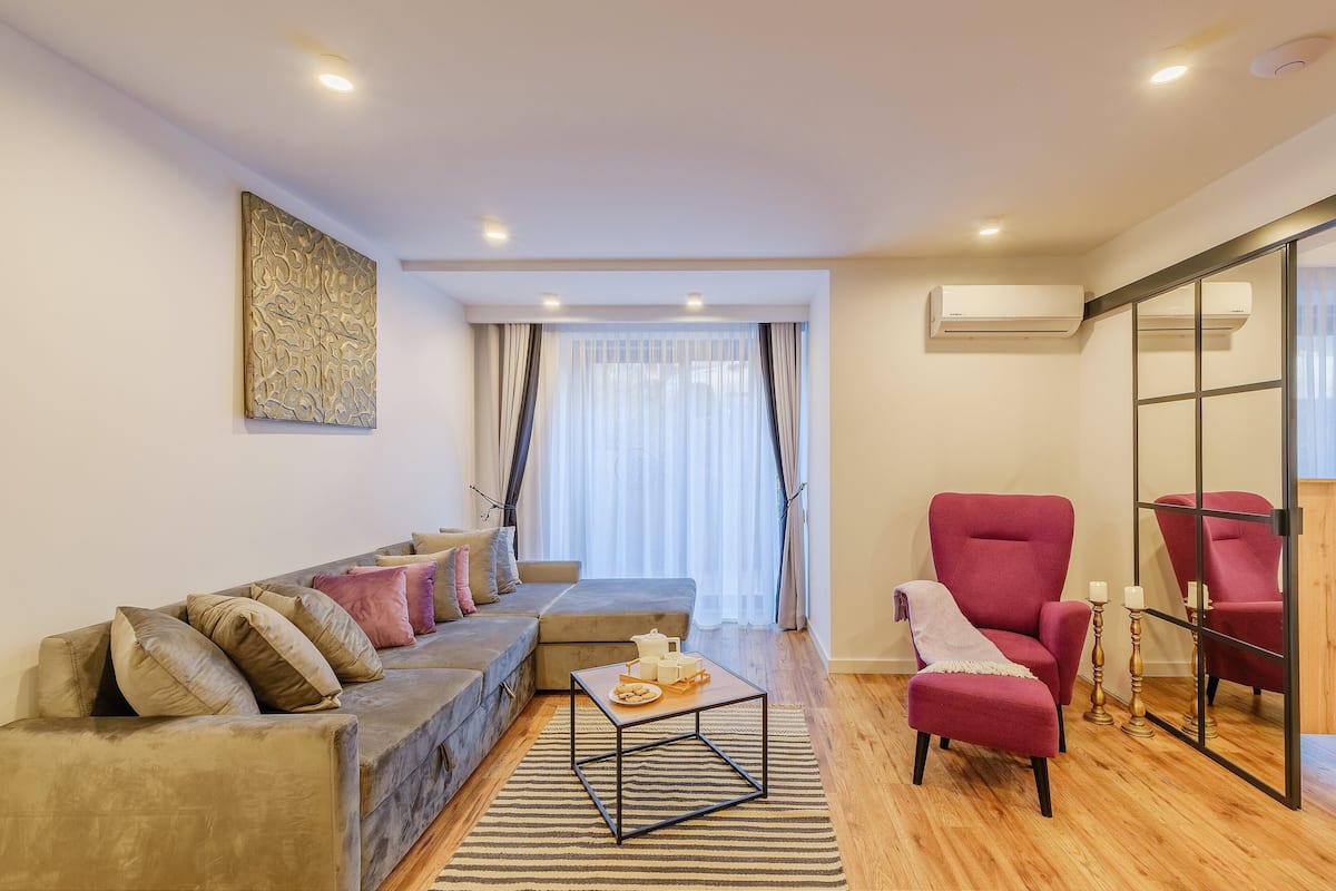 Uma sala de estar moderna com sofá, poltrona e mesa de centro.
