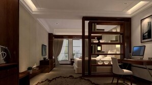 Quarto de hotel moderno com escrivaninha, cadeira e uma janela grande.