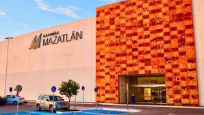 Edifício com a placa 'GALERÍAS MAZATILÁN' e área de estacionamento com vagas para deficientes azuis.