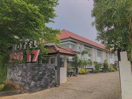 Entrada de hotel com parede de pedra e uma placa.