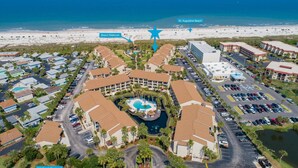Vista aérea de um resort com piscina central, acesso à praia e praia chamada St. Augustine Beach.