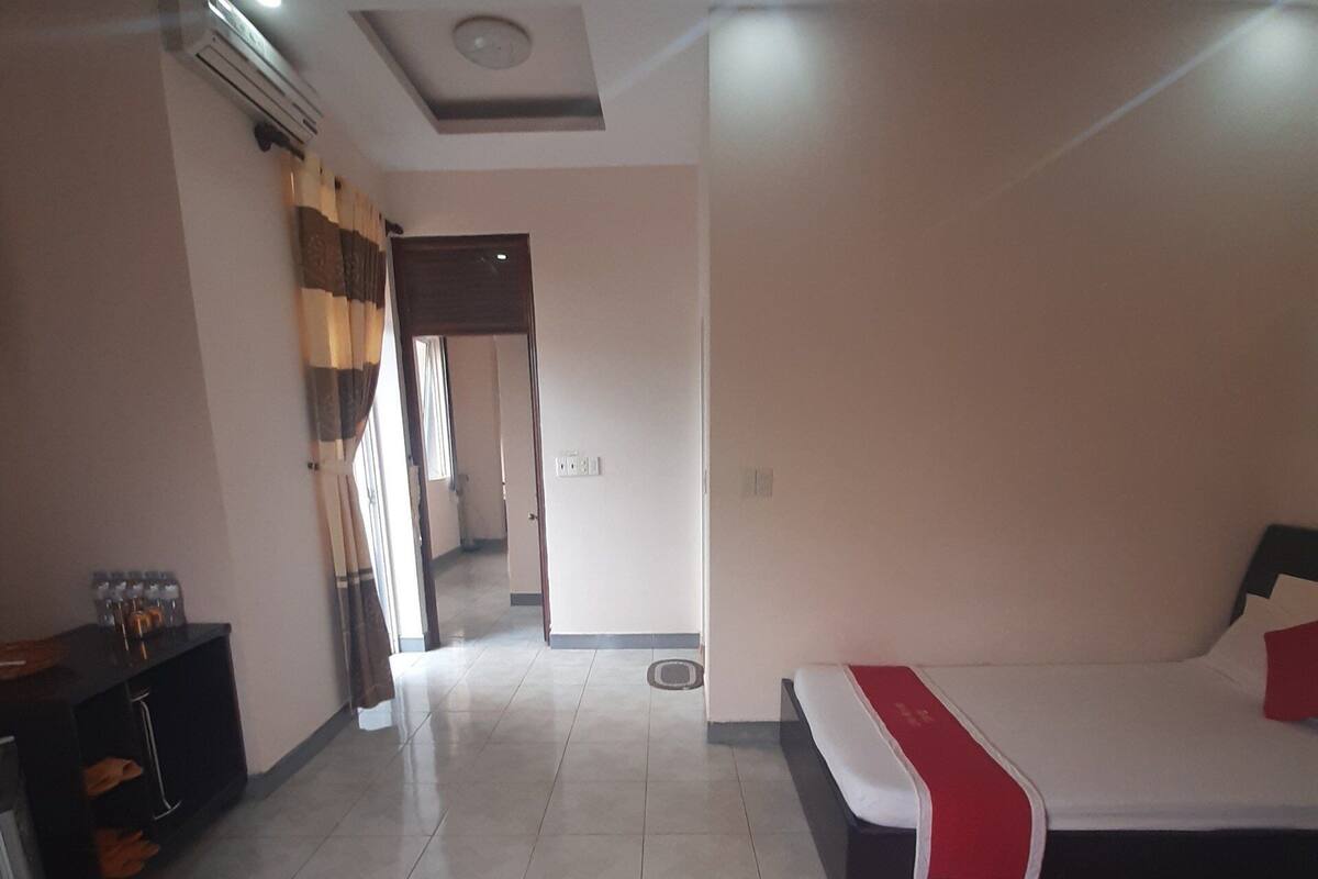 Quarto de hotel com duas camas, uma mesa e um guarda-roupa.