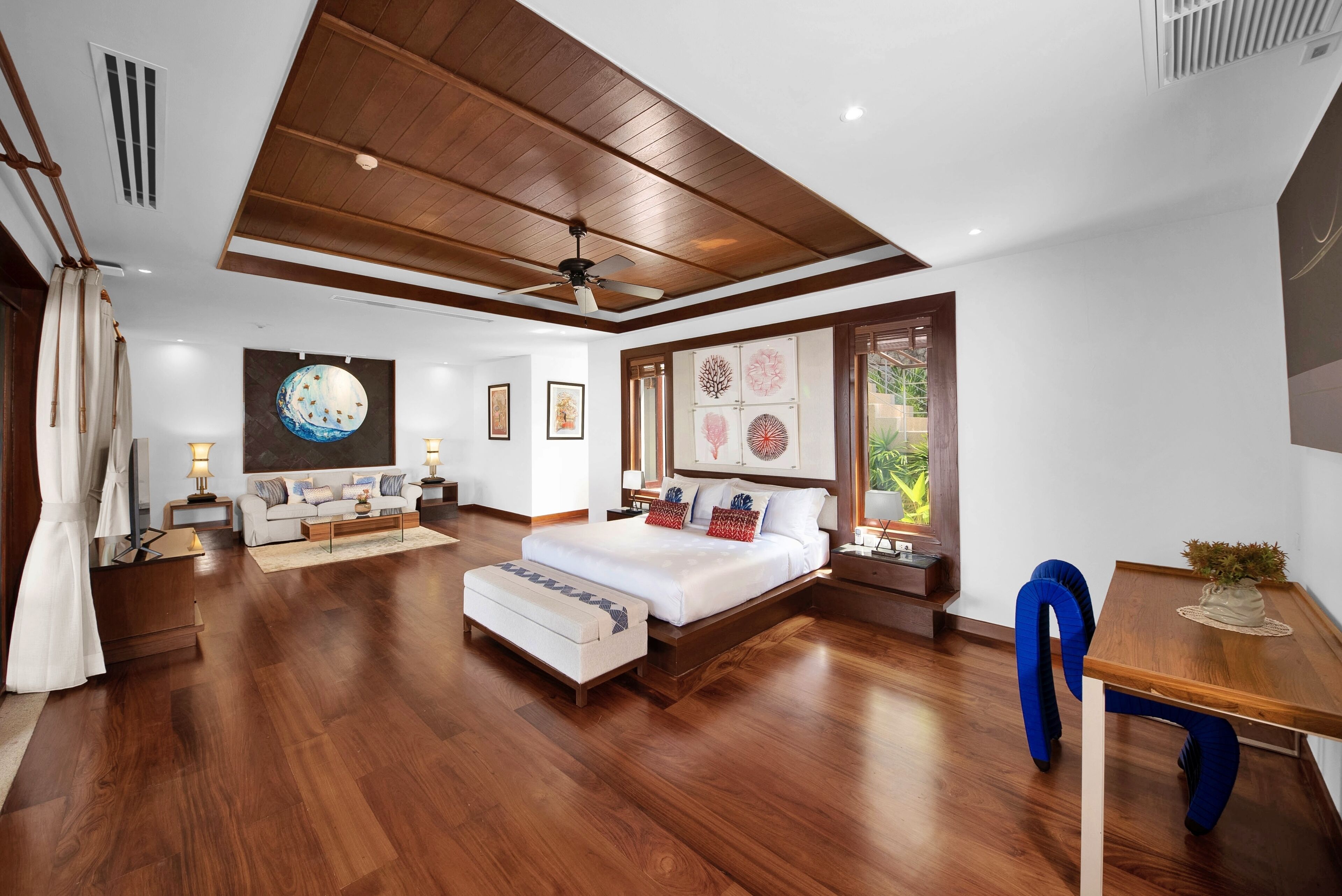 Quarto espaçoso com cama grande, escrivaninha e vista para o verde.