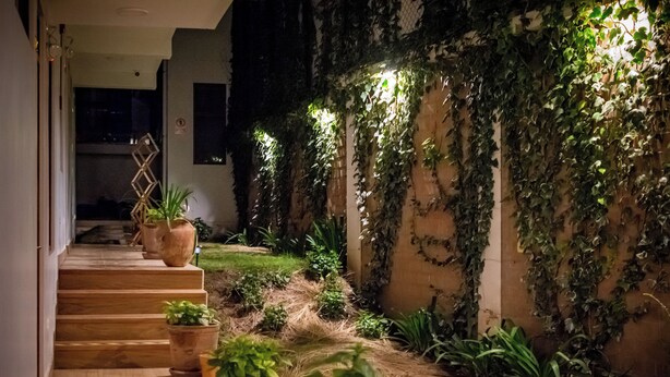 Escadaria que leva a um quarto com vista para um jardim à noite.