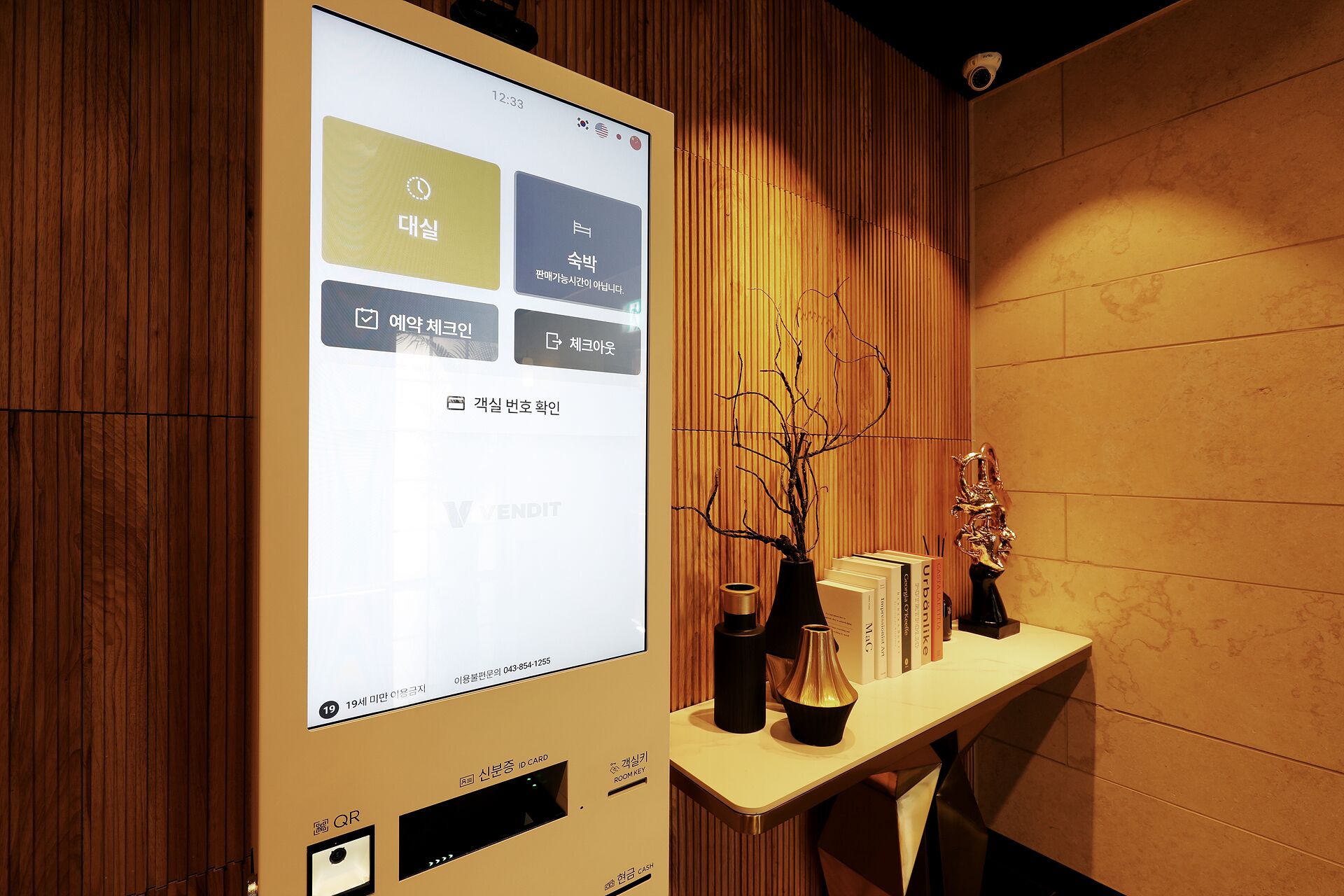Um ecrã digital com um código QR e um suporte para chave de quarto.