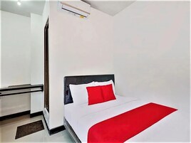 Quarto de hotel com cama, mesa de cabeceira, espelho e ar condicionado.