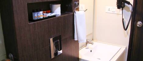 Uma casa de banho compacta com sanita, lavatório e porta-toalhas.