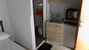 Uma cozinha compacta com armários de madeira, pia, fogão e lava-louças.