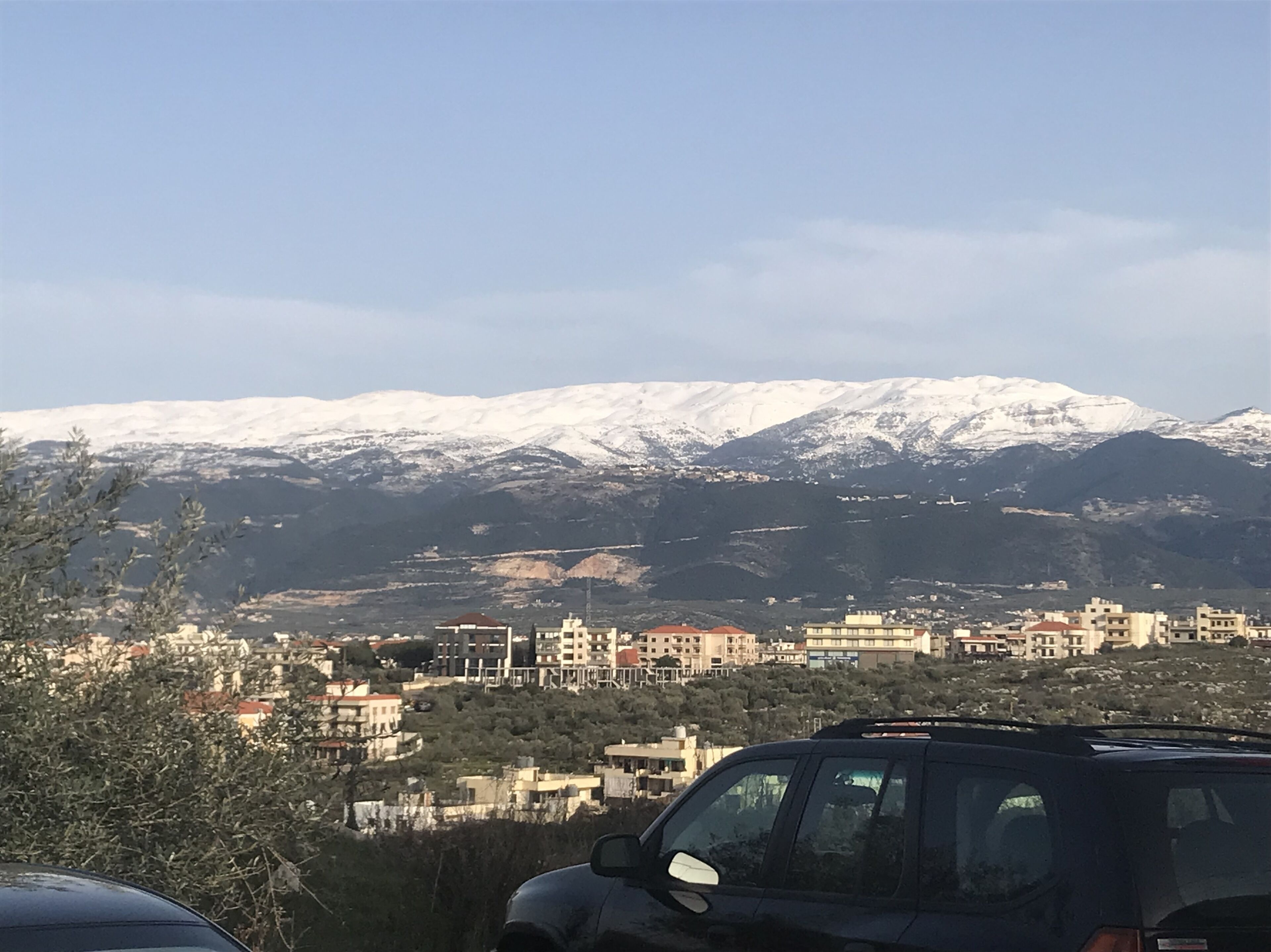 Uma cidade com edifícios e uma cordilheira ao fundo.