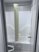 Uma banheira de imersão total, um chuveiro fixo