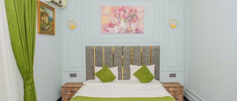 Quarto com cama, cortinas verdes, um quadro e uma mesinha de cabeceira de madeira.