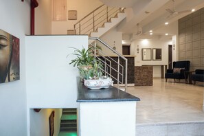 Um interior moderno com escadas, uma planta em vaso e uma área de estar.