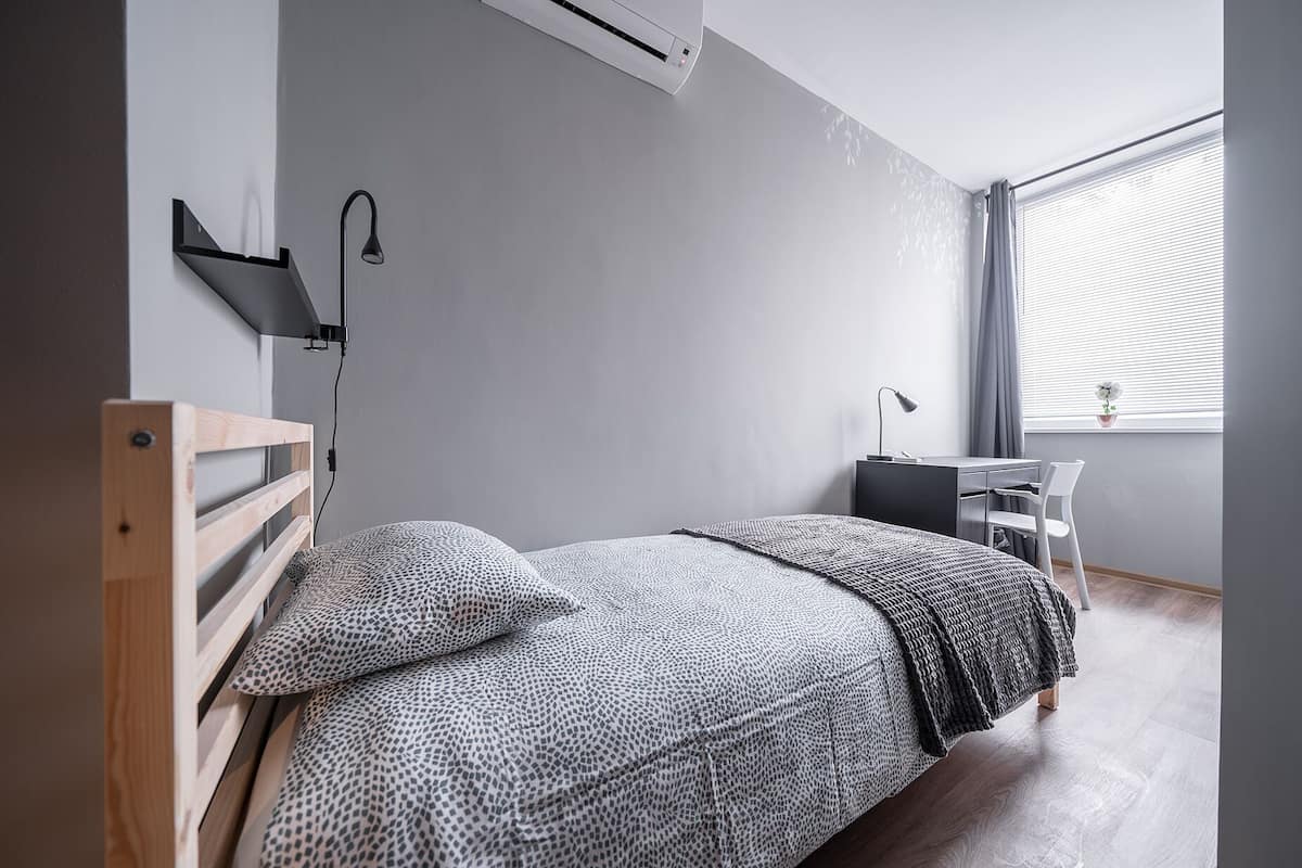 Quarto moderno com cama, escrivaninha e cadeira.