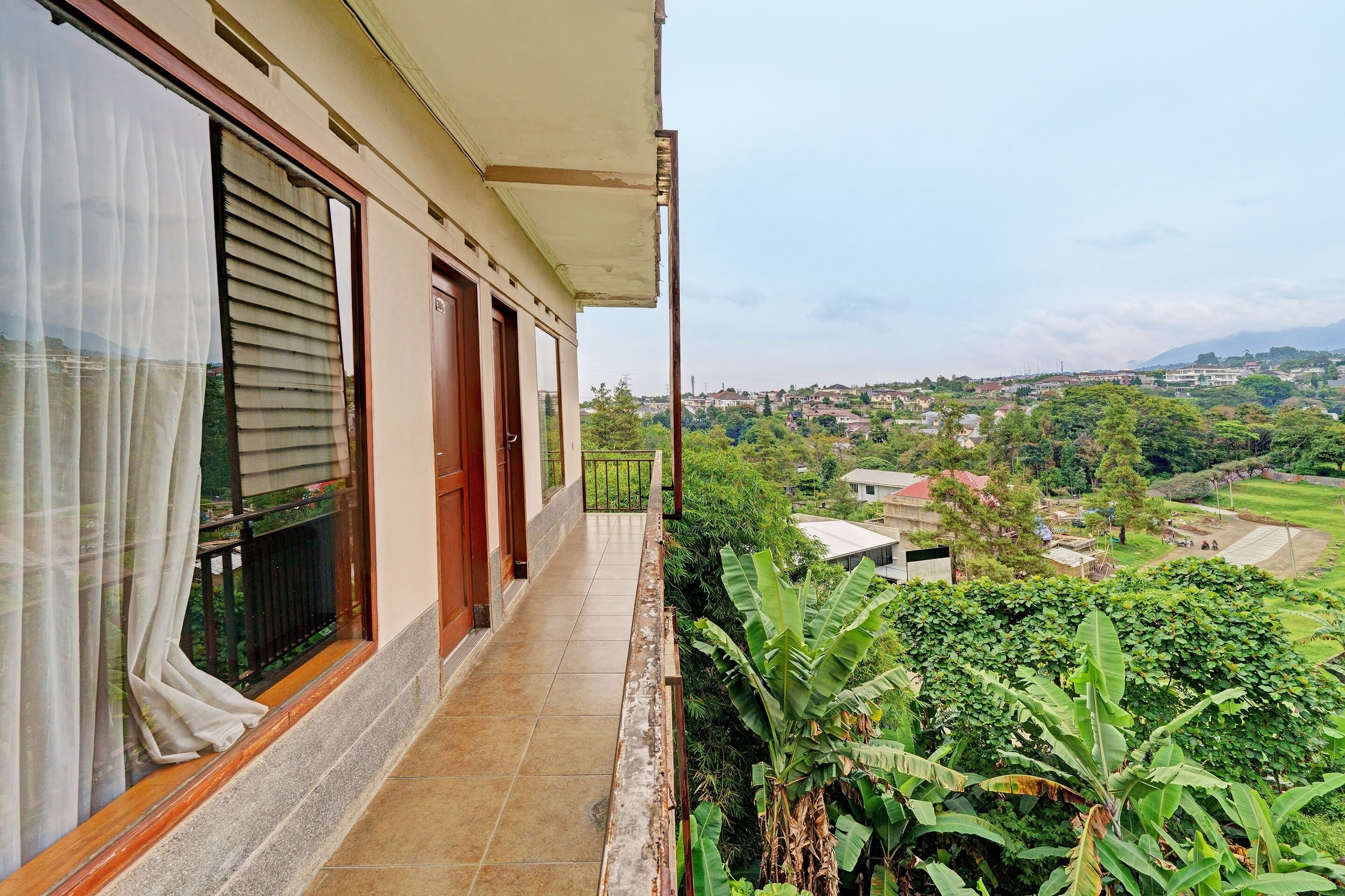 Varanda com vista para uma área residencial, com casas e vegetação.