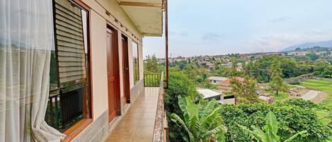 Varanda com vista para uma área residencial, com casas e vegetação.