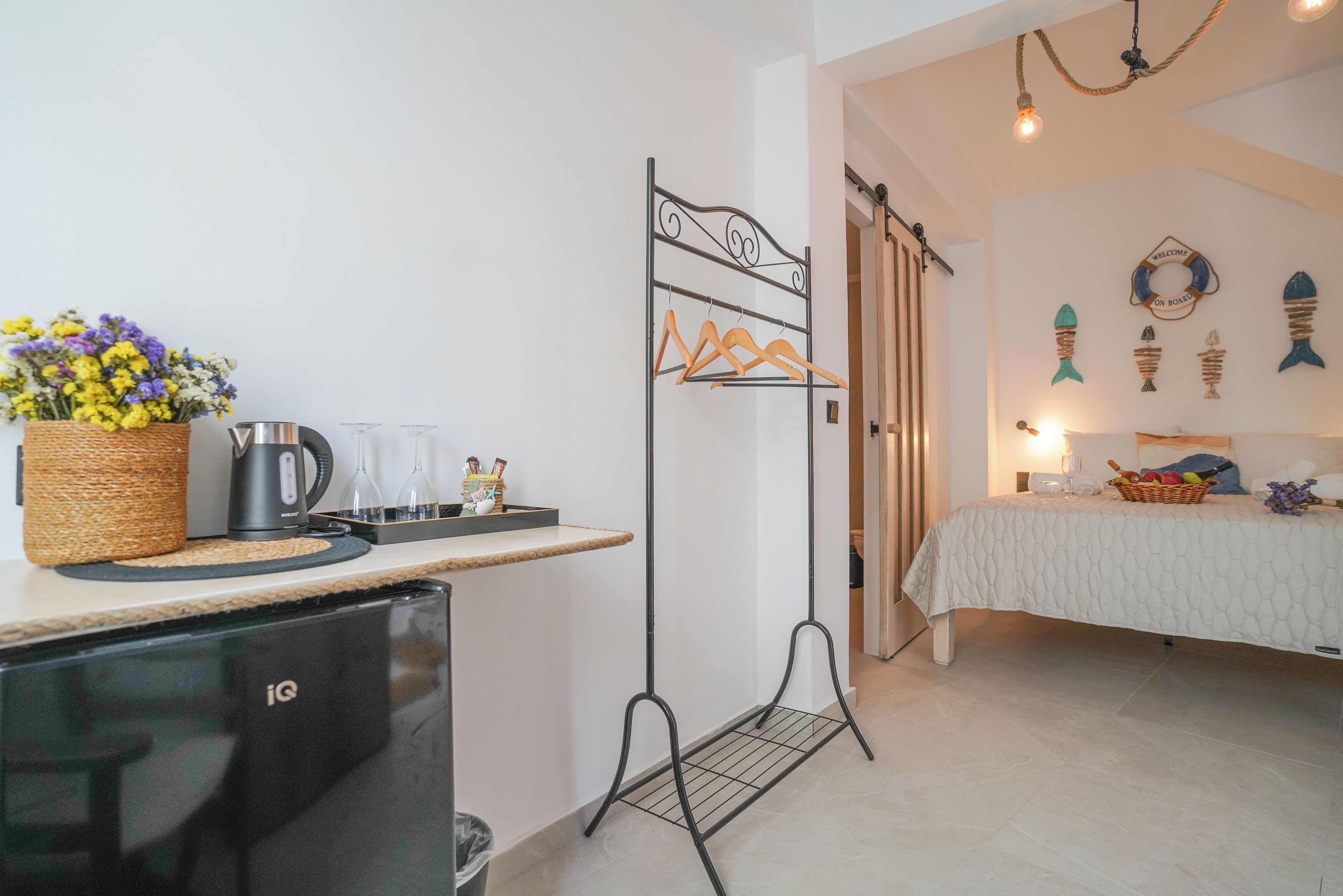 Quarto compacto com cozinha compacta, uma cama e banheiro pequeno.