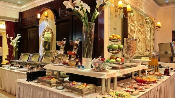 Disposição de buffet com diversos alimentos e um espelho decorativo.