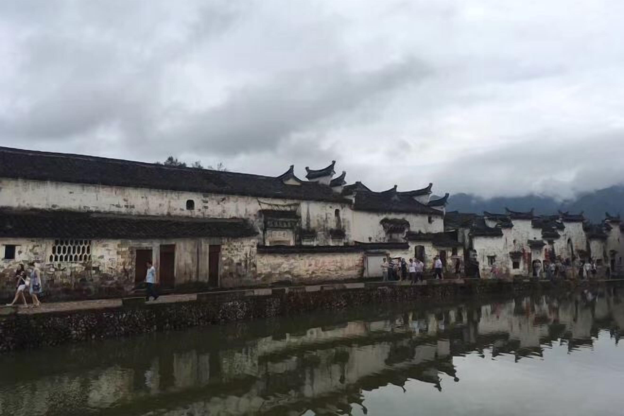 Um edifício tradicional com telhado de azulejos e reflexo na água.