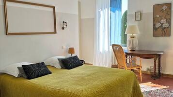 Um quarto com uma cama, uma mesa e uma cadeira.