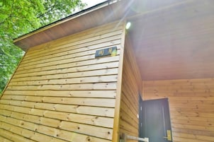 Uma cabana de madeira com porta visível e placa indicando um número de quarto.