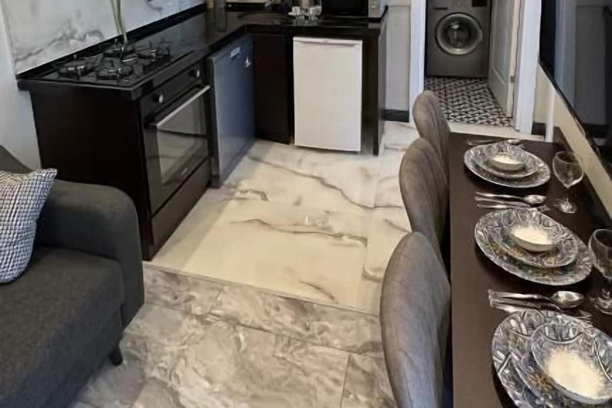 Uma cozinha moderna com área de jantar, sofá e televisão.