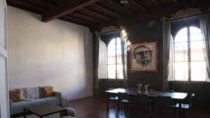 Sala de estar com sofá, mesa de centro e área de jantar com cadeiras e mesa.