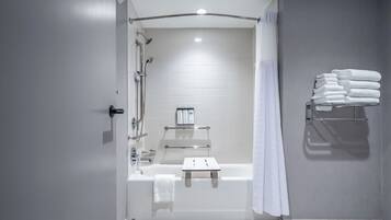 Um banheiro moderno com banheira, chuveiro e porta-toalhas.