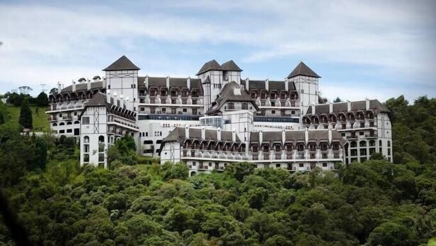 Um hotel imponente, com estilo de castelo, com várias torres e um pátio central.