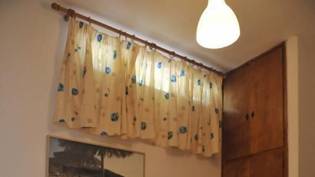 Quarto com duas camas, cabeceira de madeira, um quadro na parede e um guarda-roupa espaçoso.