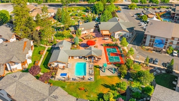 Vista aérea de uma área residencial com piscina, quadras de tênis e um pequeno parque.