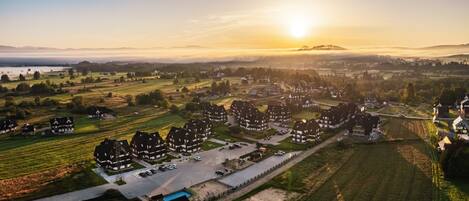 Vista aérea de uma área residencial com casas, ruas e campos.